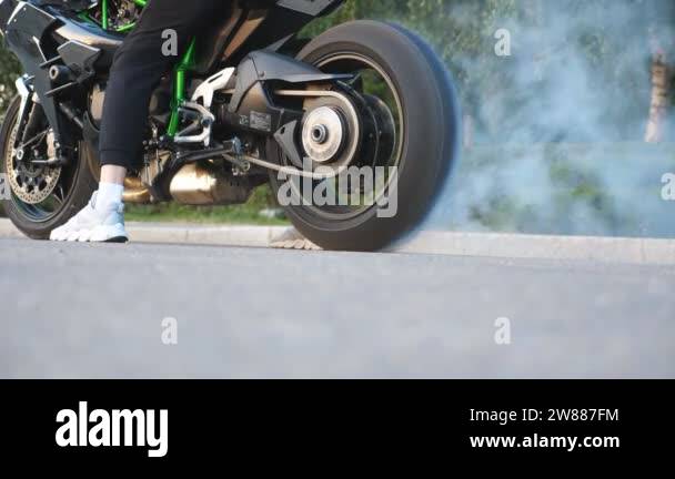 Wheel of sport motorbike starting to spin at asphalt road. Biker ...