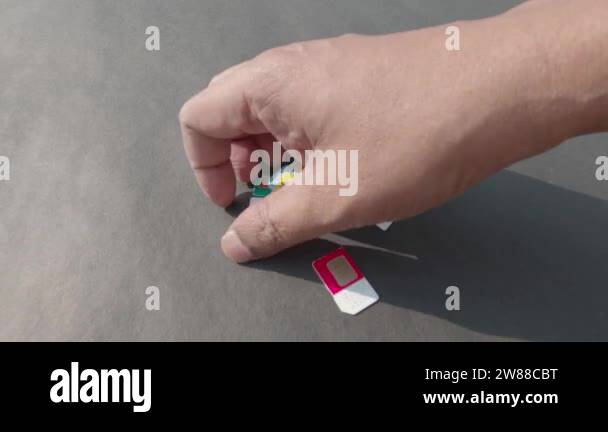 Man Hand picking up many company GSM and CDMA mobile SIM cards. These ...