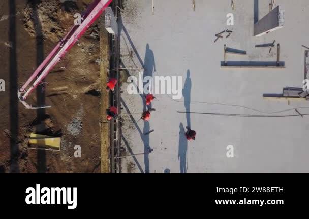Aerial of concrete boom pump crane arm truck with outriggers pouring ...