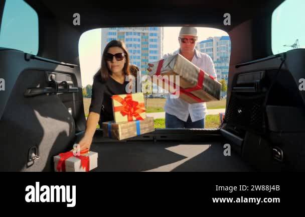delivery. donation, charity. gift boxes in car. man and woman load ...
