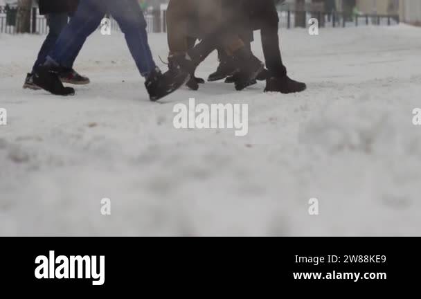 People walk on a pedestrian crossing during snowfall in winter ...