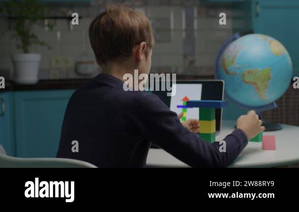 Autistic boy building with color wooden blocks using tablet computer ...