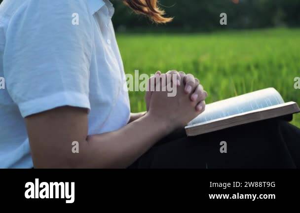 A woman sits in prayer, talking to God through prayer. Praying with her ...