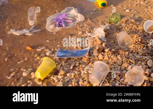 Disposable face masks and plastic debris on the beach in surf zone ...