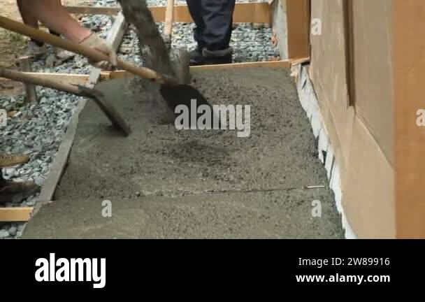 Workers are pouring concrete into the formwork of the house. Workers ...
