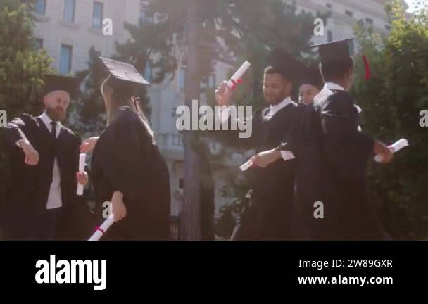 Multiethnic students graduates dancing after the graduation in the ...