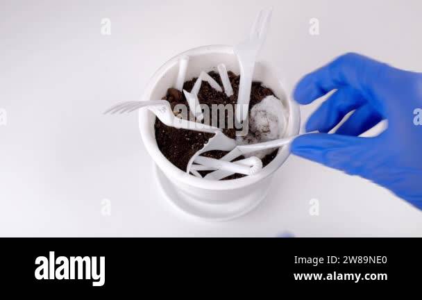 Rubbish in the ground. White pot with earth on a white background. Blue ...