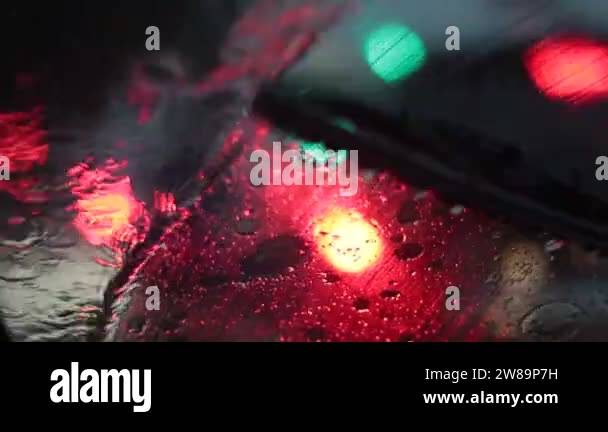 Rain falling on car windshield view. Drive car on traffic jam street at ...