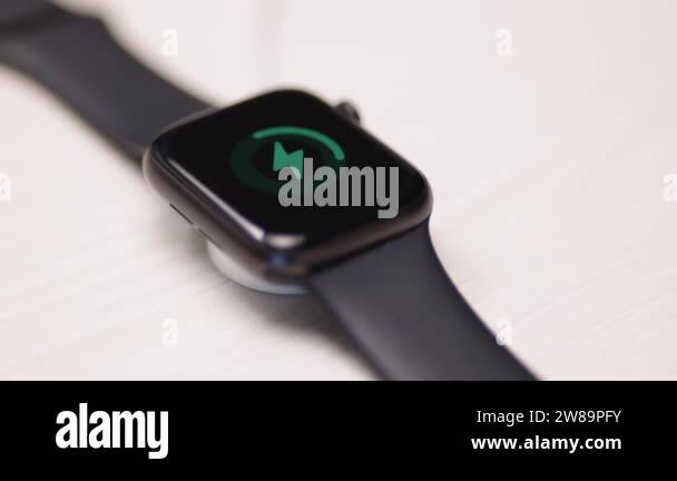 Charging smartwatch. Closeup of smart watch charging with wireless ...