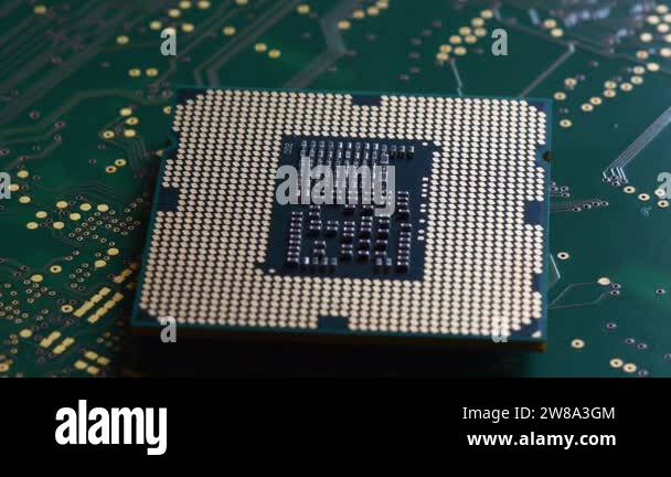Close-up of a computer processor on green electronic board with golden ...