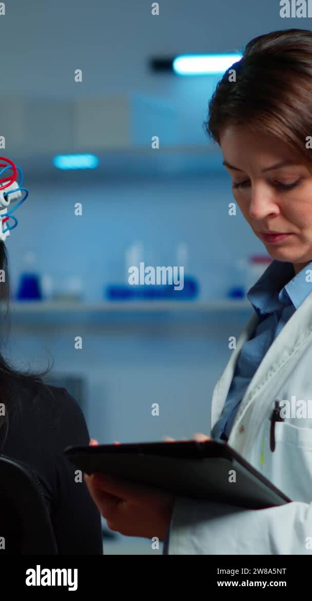 Vertical video: Woman patient wearing performant eeg headset scanning ...