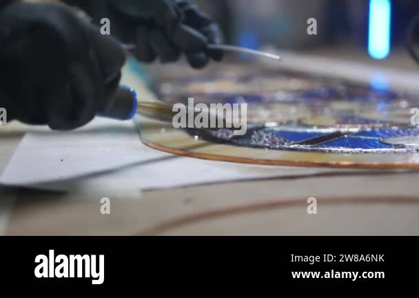 Close-up The process of soldering stained glass seams. Gloved hands ...