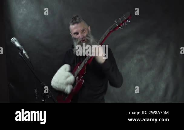Bearded rockstar with black hoodie, red electric guitar and shaved ...