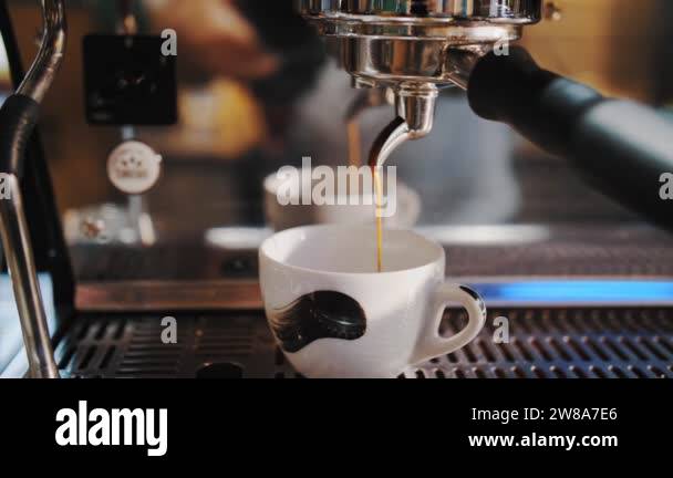 coffee drink. close-up. barista prepares coffee using espresso machine. thin stream of coffee ...