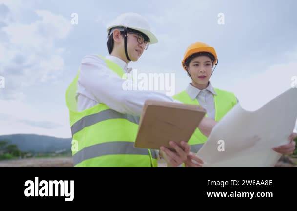 Two happy workers preparing themselves for outdoor working, engineering ...
