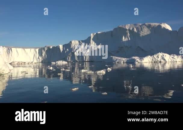Arctic sailing among glaciers and floating ice blocks, in frozen sea ...