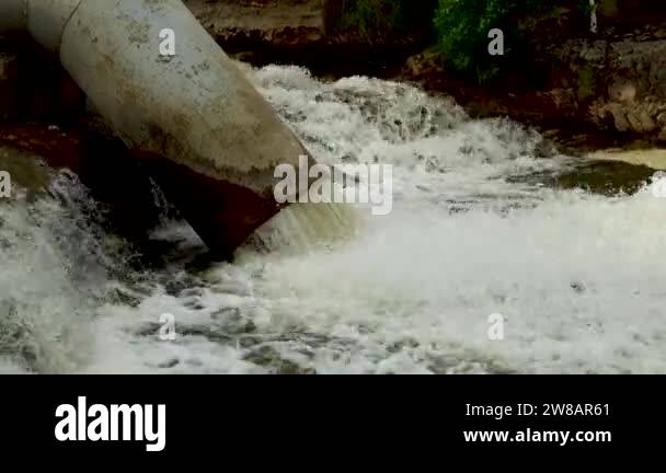 Dirty water and chemical waste are poured out of the pipe into a ...