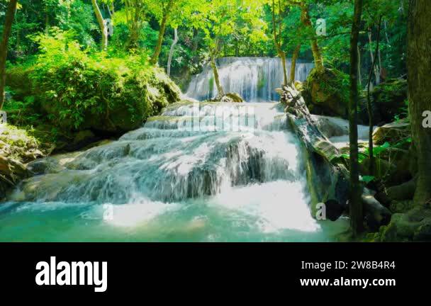 Waterfalls and fish swim in the emerald blue water in Erawan National ...
