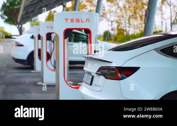 Autonomous electric Tesla car refilling battery energy on supercharger ...