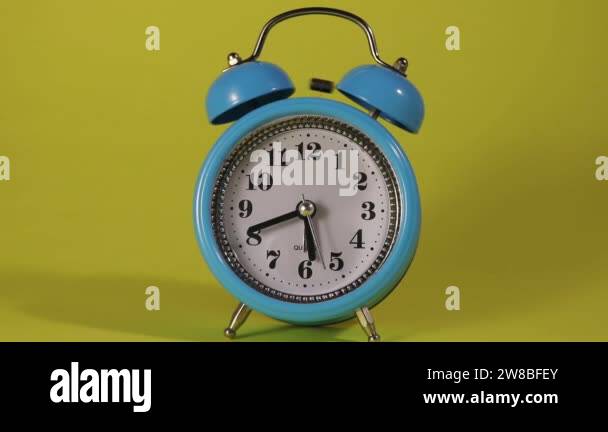 The alarm goes off at 6 am in the bedroom against the yellow wall. It's ...