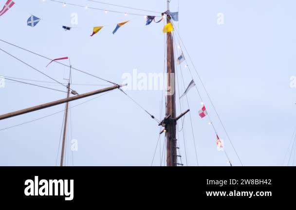 Flags and lamps on the mast of an old sailing ship on the cloudy sky ...