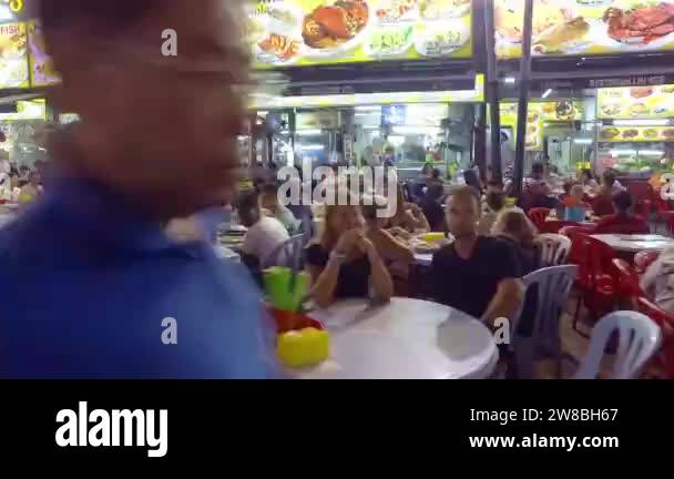 People eating outside at night in a street full of restaurants in Kuala ...