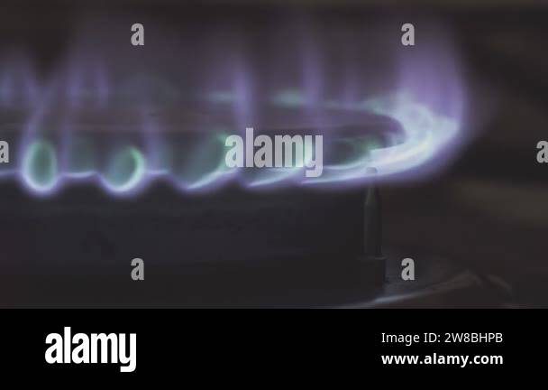 Methane firing up with blue flame on gas stove burner in total dark ...