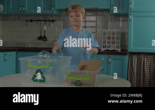 Boy in blue Volunteer T-shirt sorting paper and plastic bottles into ...