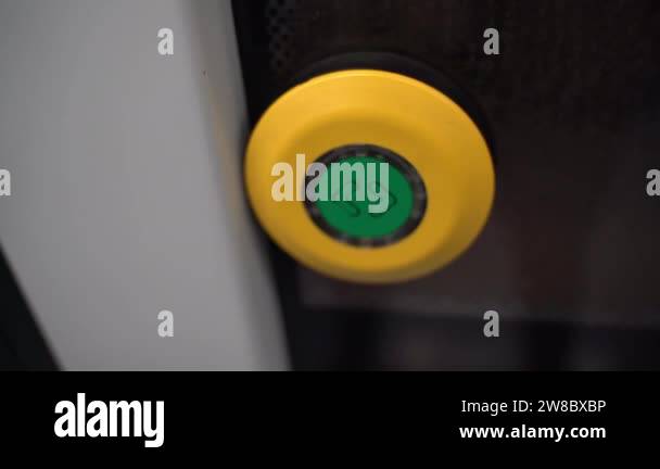 Illuminating push button on metro train doors, yellow and green button ...