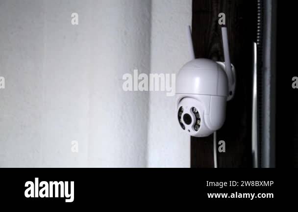 White CCTV camera with antennas rotates and records moving objects ...