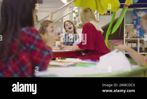 In primary school children drawing in the classroom with a female ...