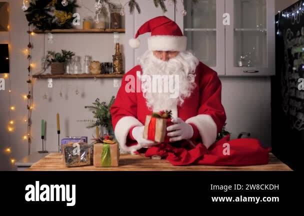 Happy Santa Claus catches box with gift and hands it to audience. Santa ...