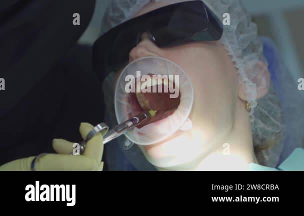 real. dentist injects an anesthetic into patient before tooth ...
