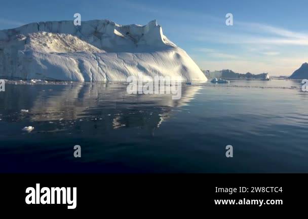 Arctic sailing among glaciers and floating ice blocks, in frozen sea ...