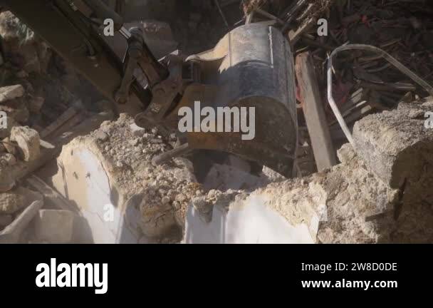 Demolition of ancient historical buildings, excavator breaks down an old vintage house ...