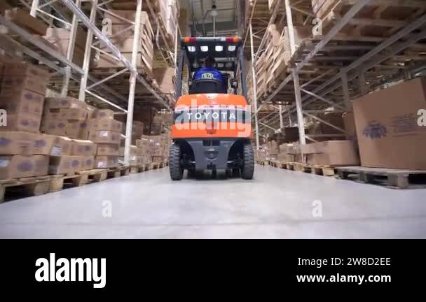 Forklift Trucks Move Between Large Metal Shelves at a Modern Warehouse ...