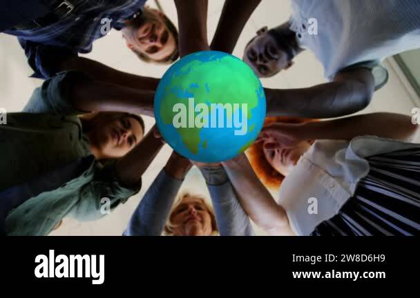 Animation of globe over work colleagues stacking hands in background ...