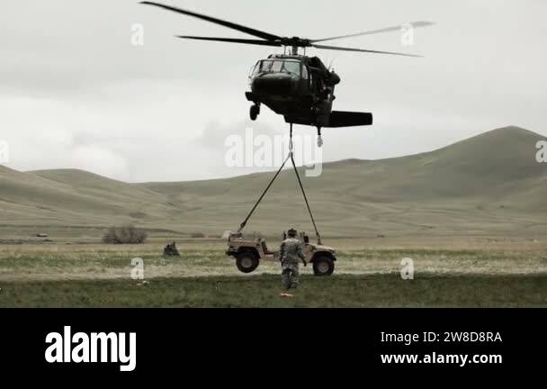 helicopter lifting Humvee while soldier gives signals to pilot Stock ...