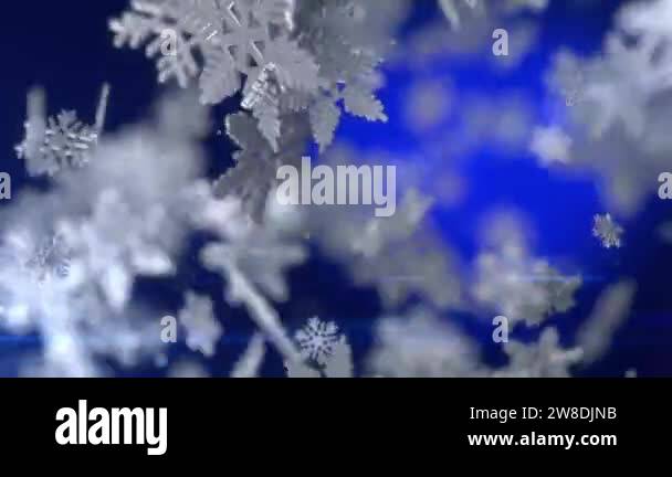 Aslant moving white snowflakes rotating around and flying in the blue ...