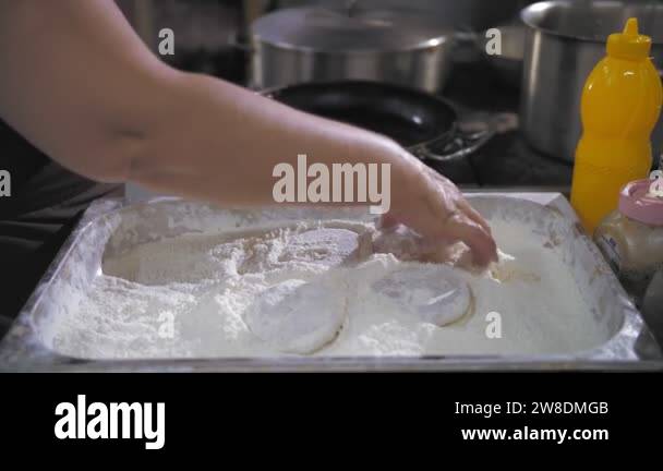 burger patty. close-up. cooking. buffet restaurant kitchen. chef dips ...