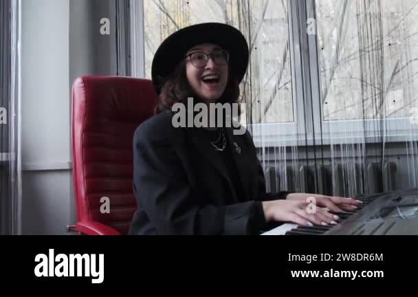 A young teacher is engaged with students by a special method. Music ...