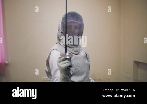 fencing. white fencing uniformed fencer, in fencing safety helmet, is ...