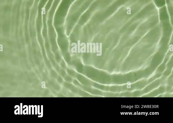 Water splash green colored. Drop falls into water and diverging circles ...
