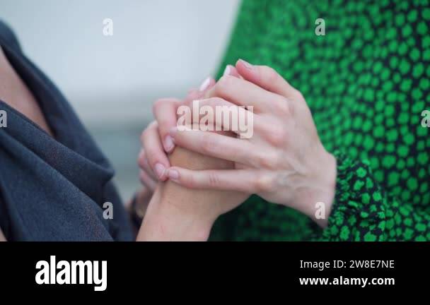 Close-up two women holding hands caressing palms supporting each other ...