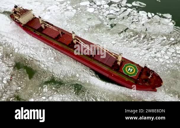 Aerial above epic huge steel icebreaker breaks ice by bow of ship and ...