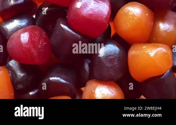 Close-up texture of red, orange and purple multivitamin gummies on ...