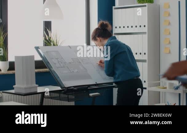 Close up of woman architect taking notes on blueprints plans to design ...