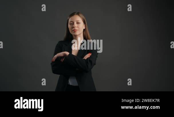 Confident ambitious business woman in black suit watches to the camera ...