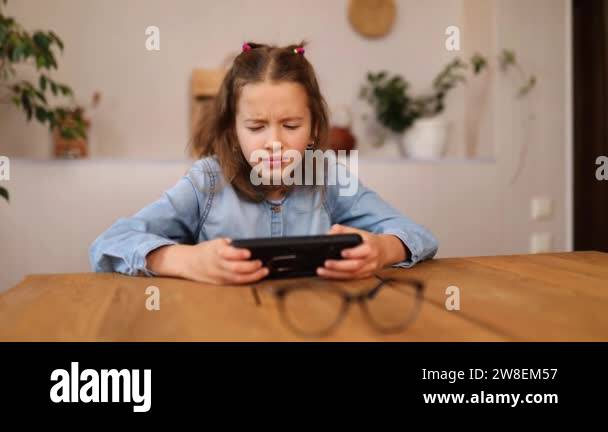 Poor eyesight Little girl in play game on smarthone, child dependence ...