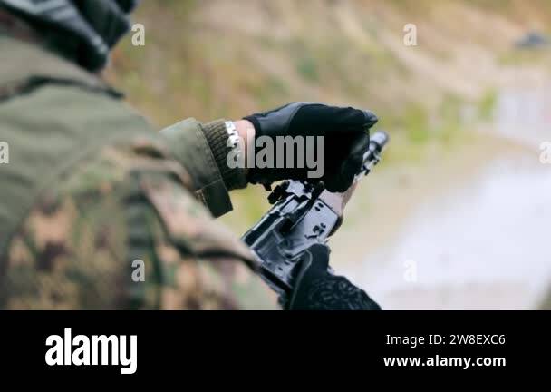 A military shooter discharges a machine gun from ammunition. Close-up ...